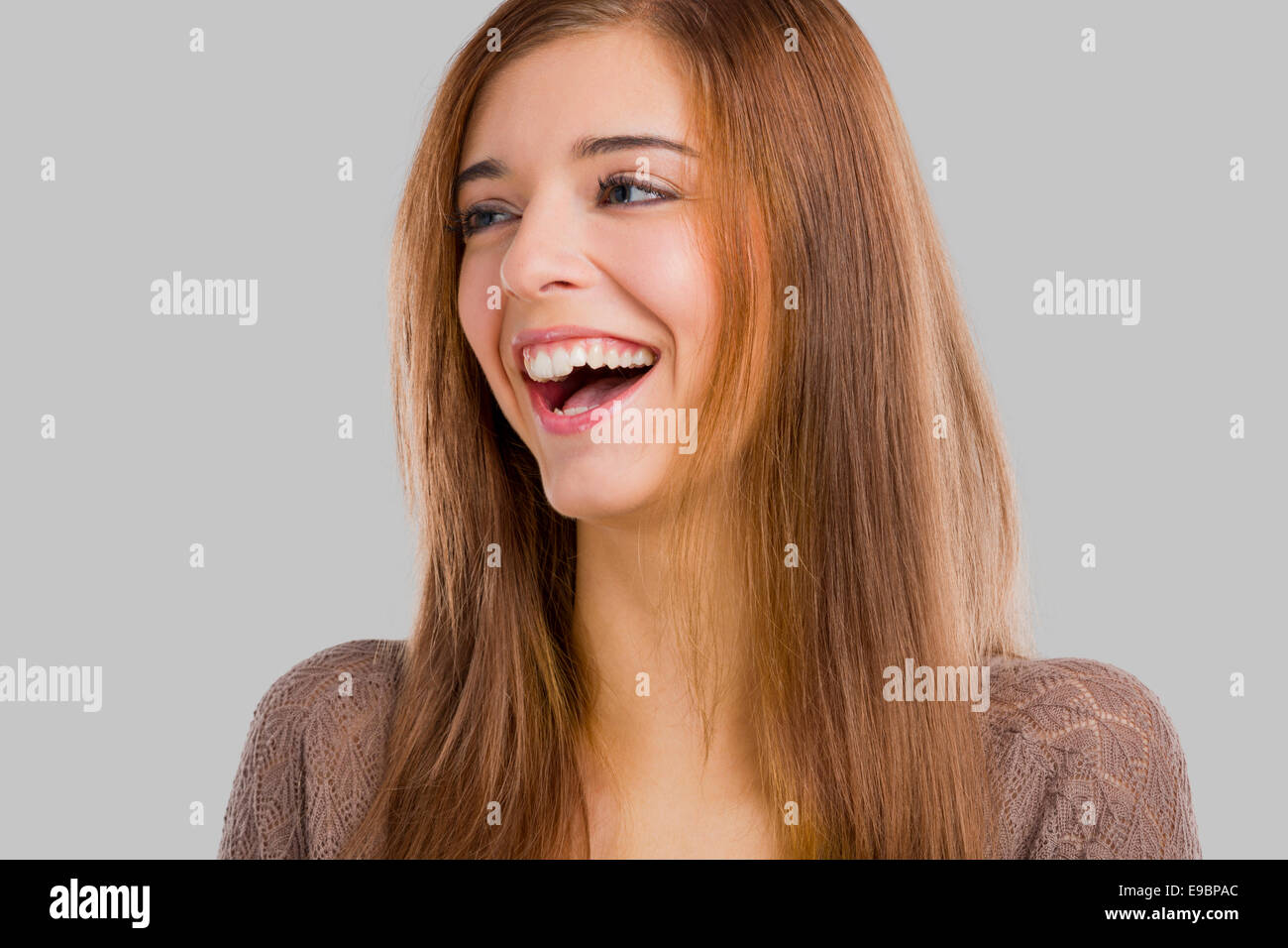Beautiful and happy woman laughing over a gray background Stock Photo ...