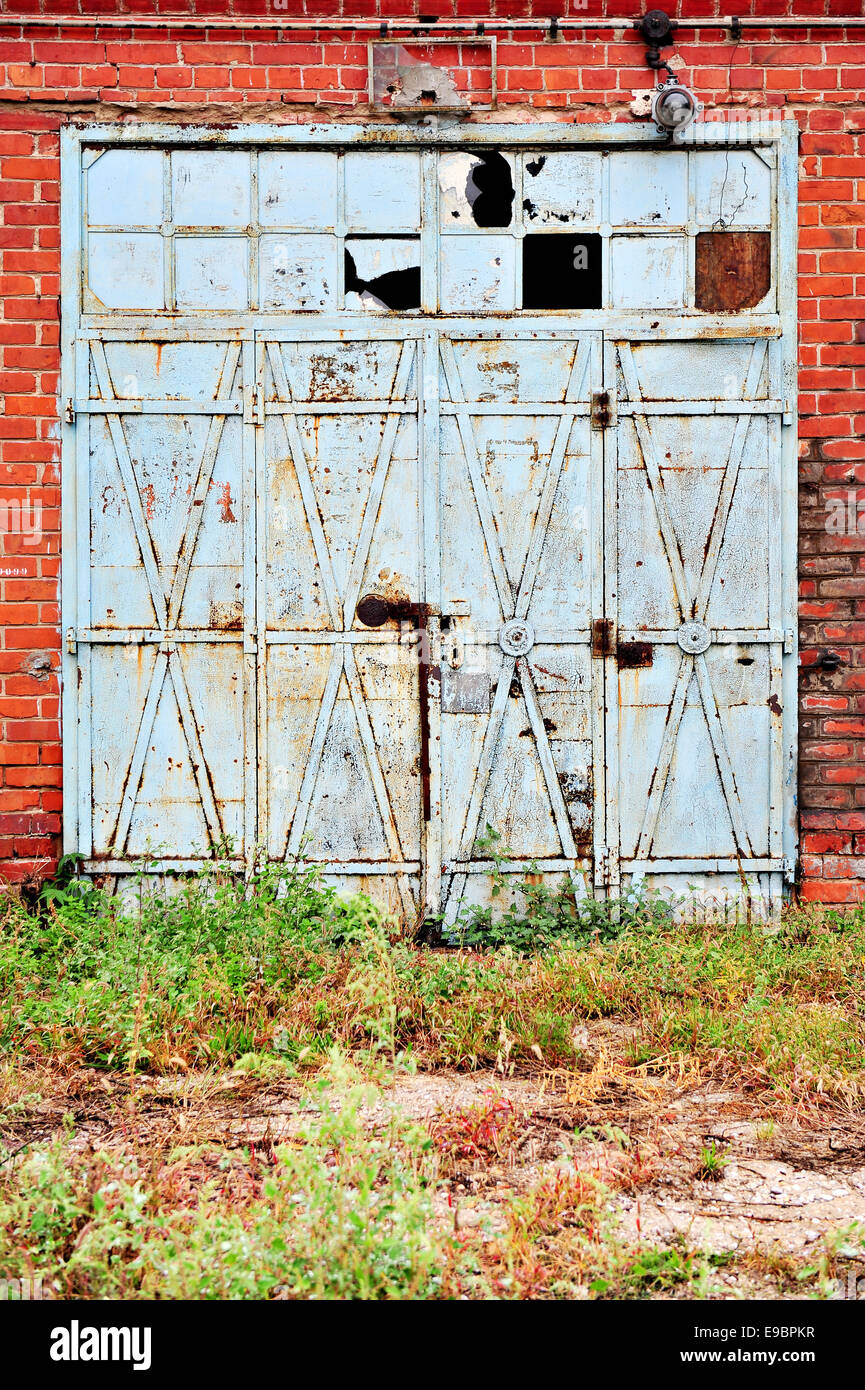 Old and rusty blue iron gate from an abandoned brick warehouse Stock ...