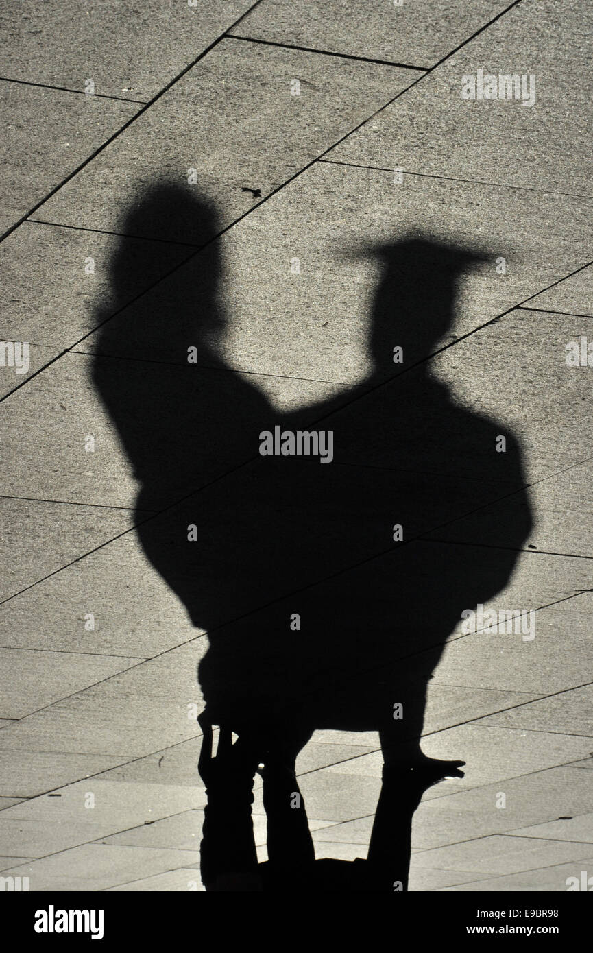 Shadow figures of graduates on graduation day dressed in gowns and ...