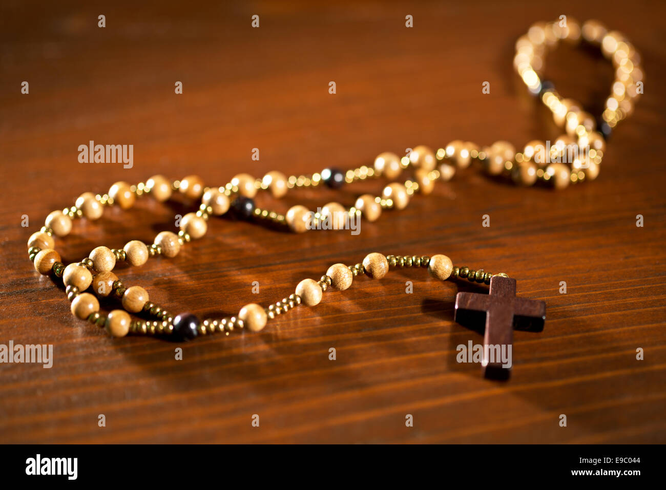 A rosary on the brown wooden table Stock Photo - Alamy