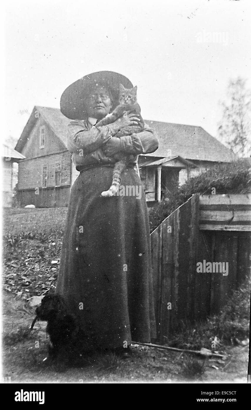 A photograph of Edith Södergran's mother, Helena, standing with a cat ...