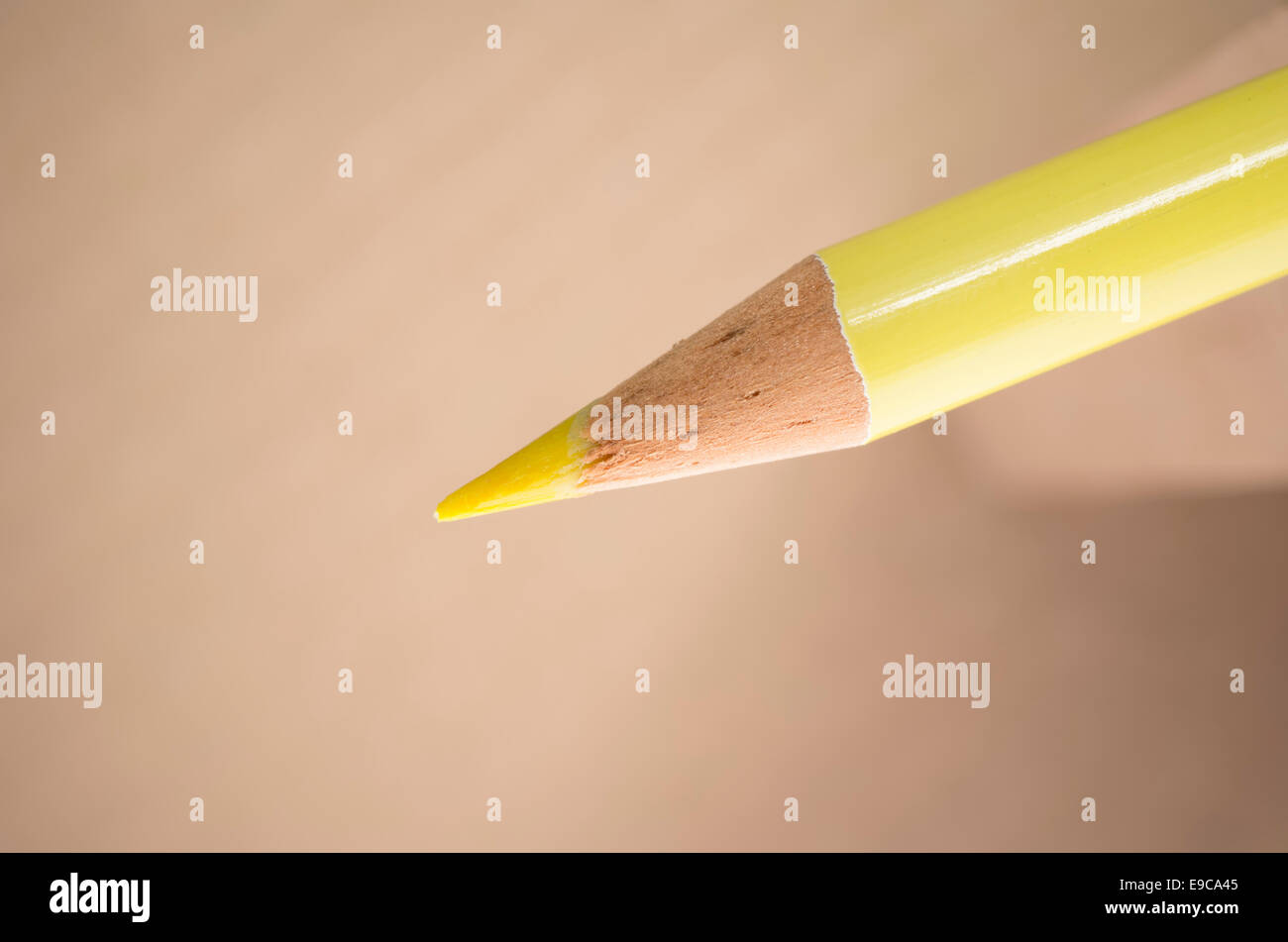 yellow colored pencil close up on a blurred light brown surface Stock ...