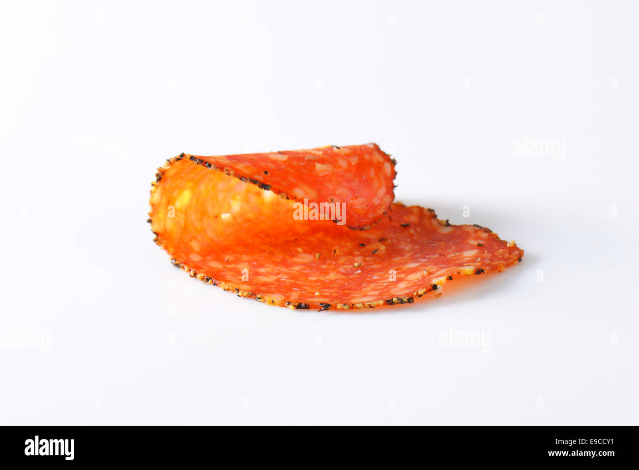 Thin slice of black pepper-coated salami speckled with pieces of Comte ...