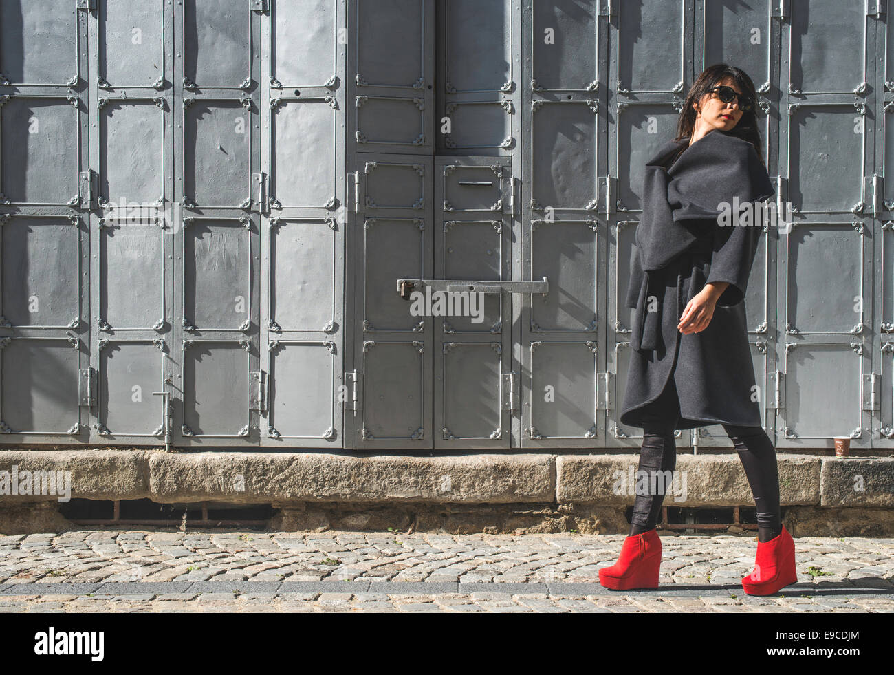 Woman walking on a street. Grey background Stock Photo - Alamy
