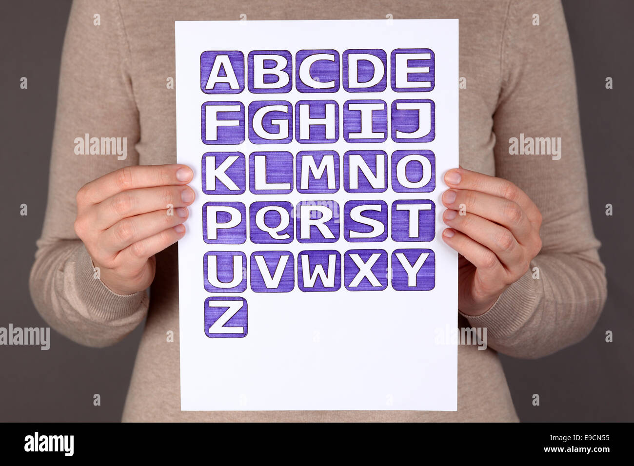 Woman's hands hold page with drawing alphabet's letters. Letters paint ...