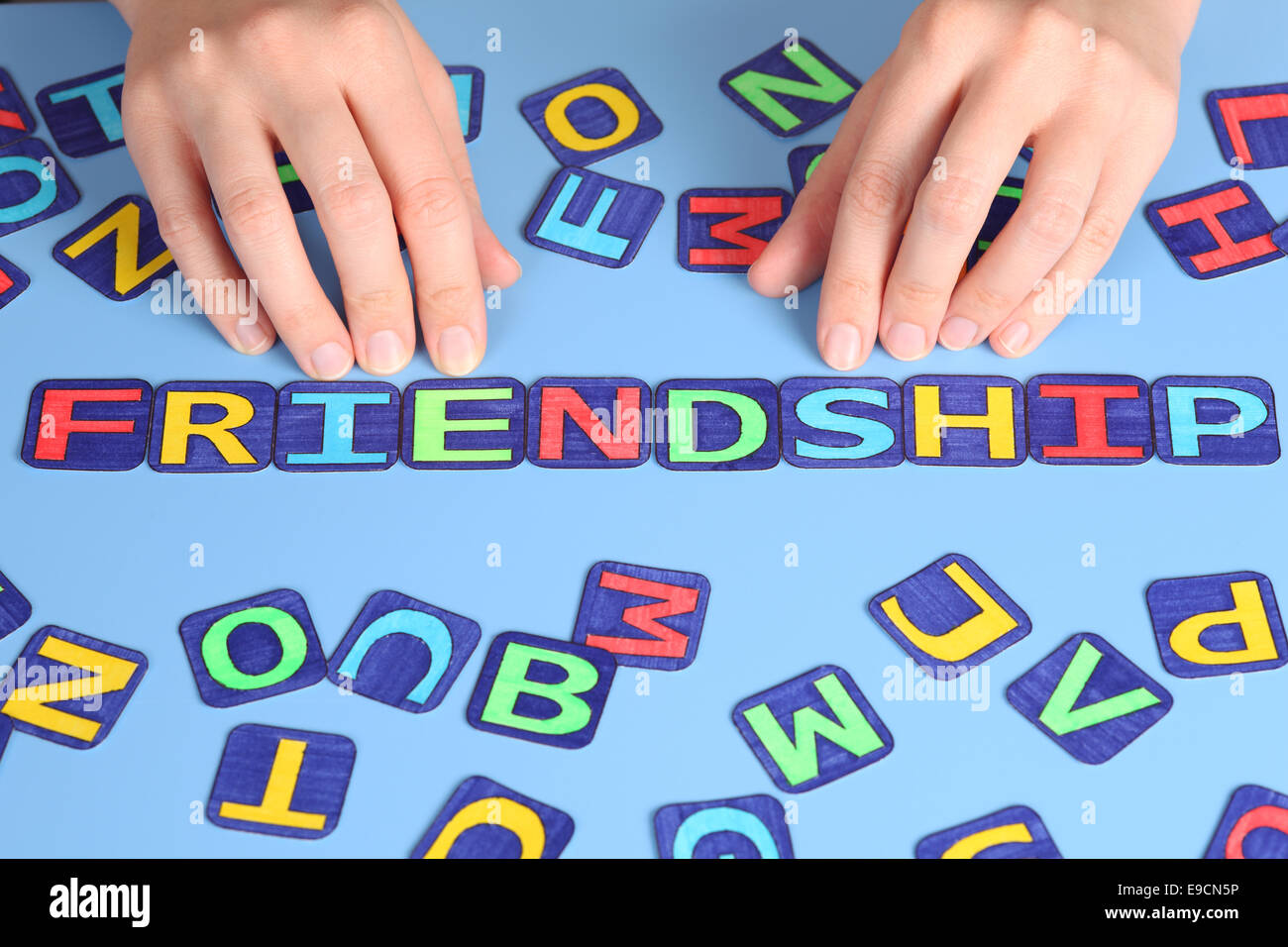 Word Friendship spell out on a desk with woman's hands and letters ...