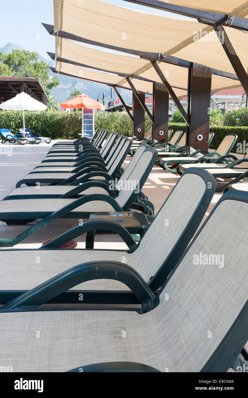 Lounge sunbeds near swimming pool Stock Photo - Alamy