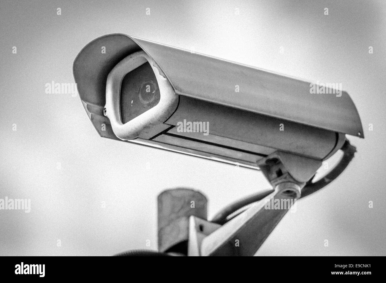Security camera. Sky in background. Black and white with grain added ...