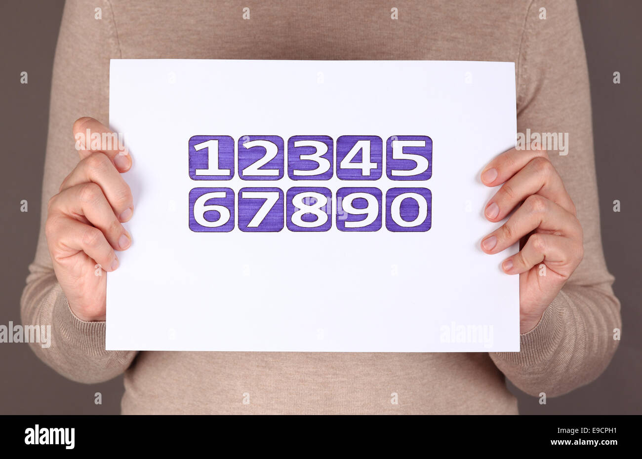 Woman's hands hold page with drawing numbers from 1 to 0. Numbers drawn ...