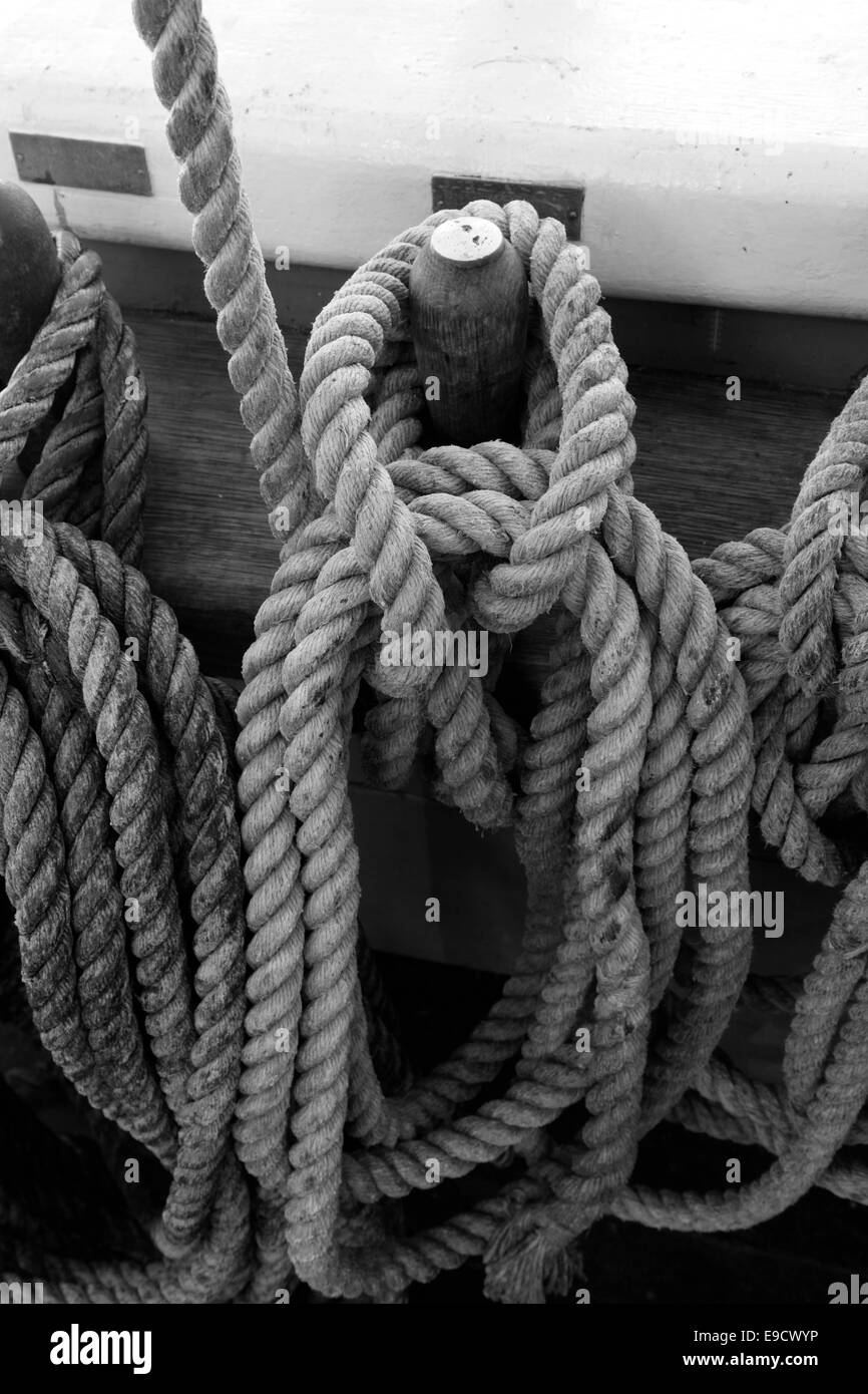 Belaying pins with coiled ropes on a tall ship Stock Photo - Alamy