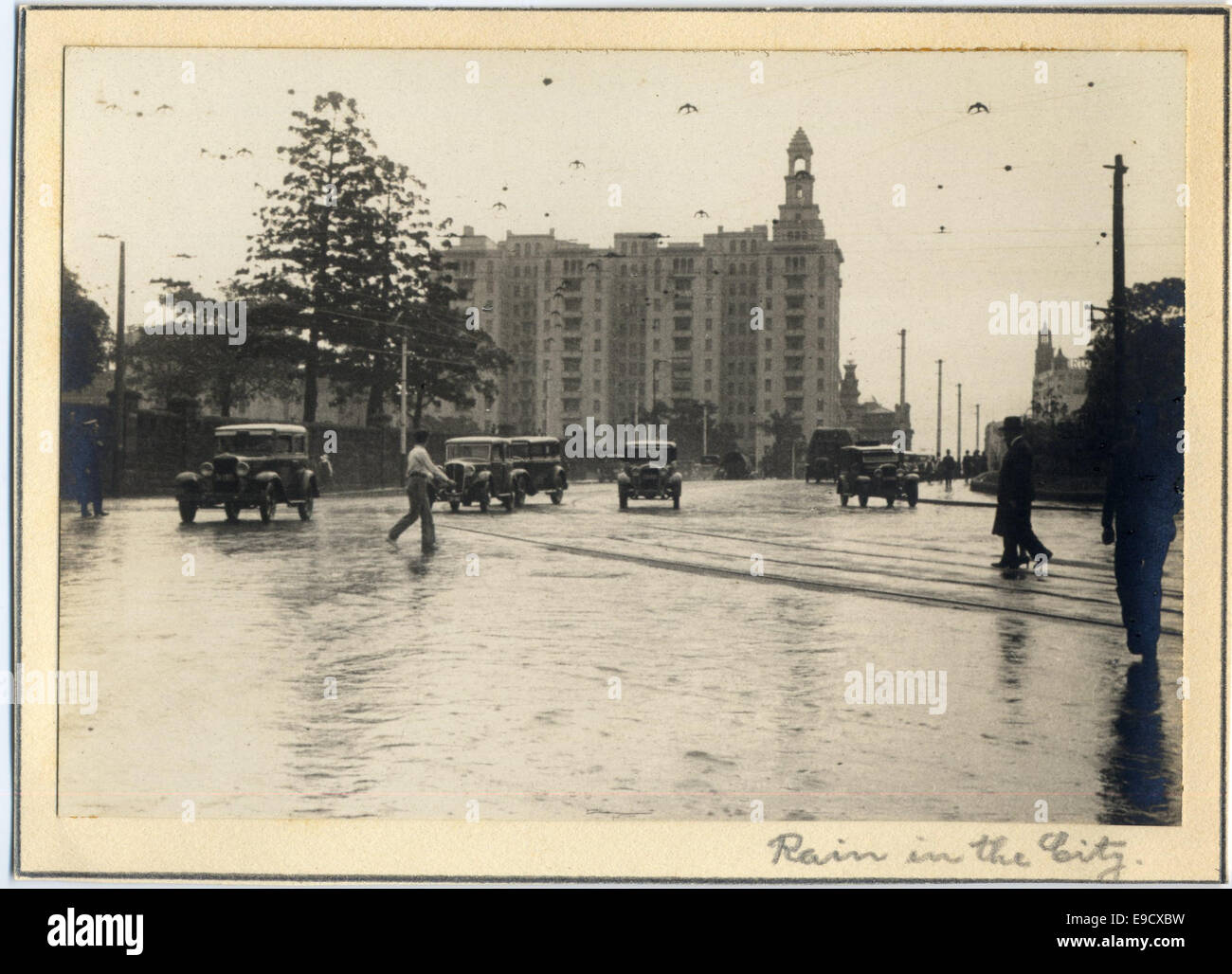 This photograph captures a scene of rainfall in an urban setting ...