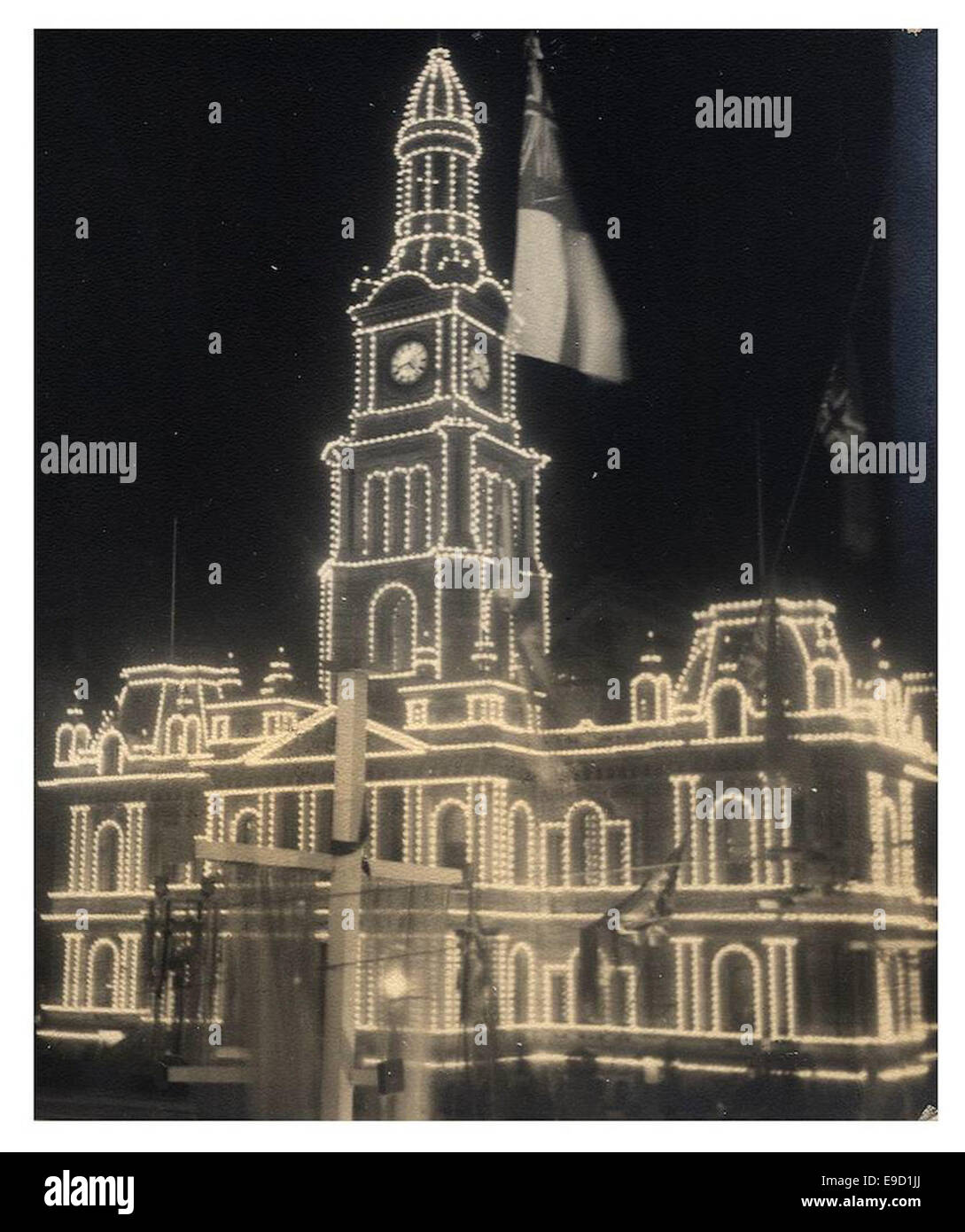 This photograph shows Sydney Town Hall illuminated at night, with its ...
