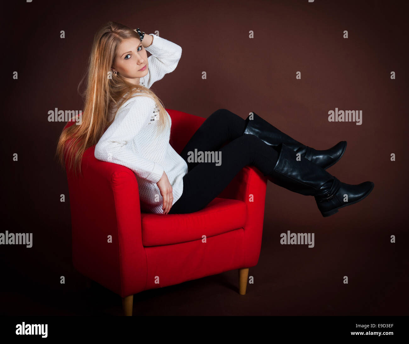 Beautiful young girl sitting on a chair Stock Photo - Alamy