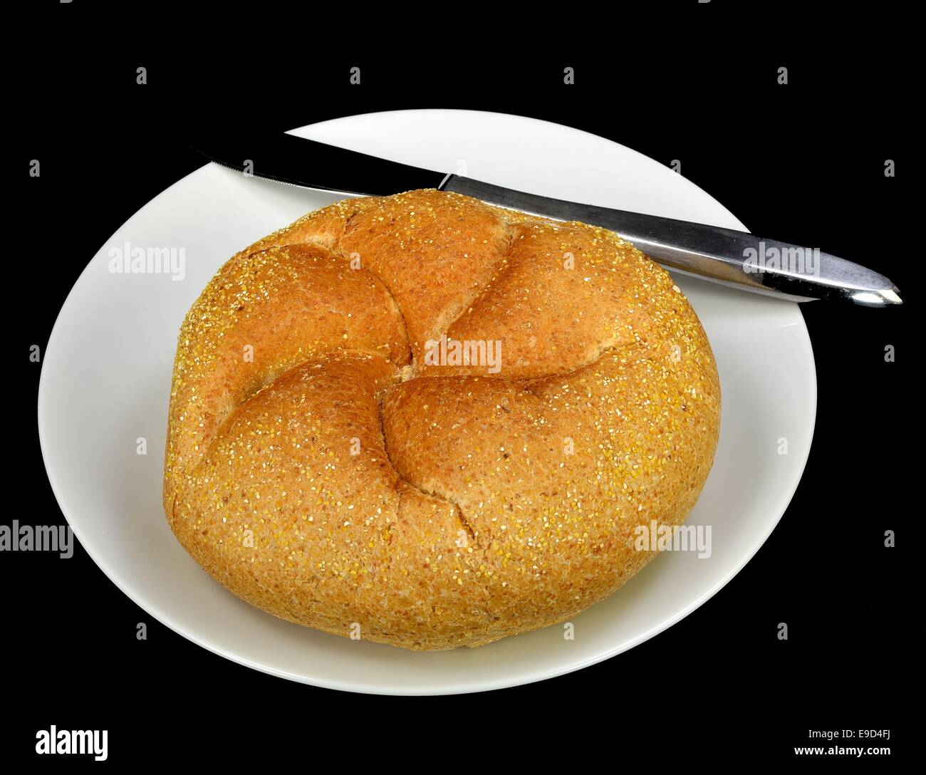 Whole wheat kaiser roll on a black background Stock Photo - Alamy