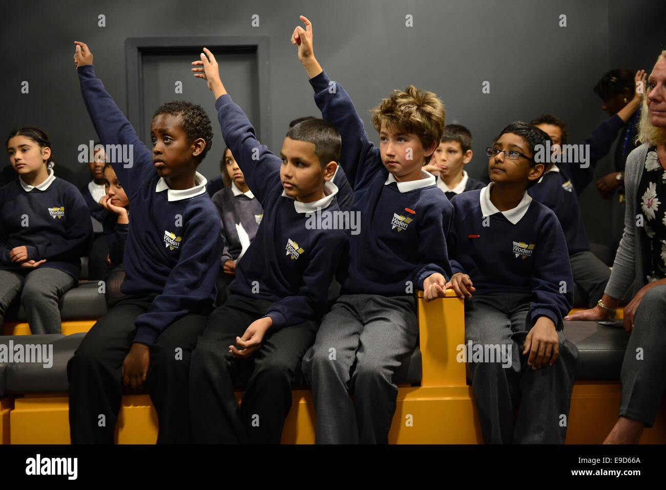 School boys children putting hands up in classroom UK Woden Primary ...