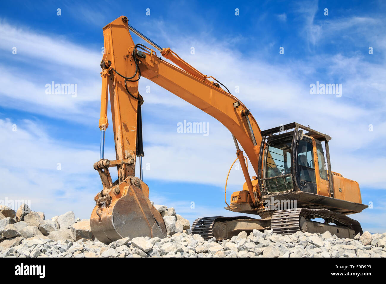 Yellow excavator against blue sky Stock Photo - Alamy