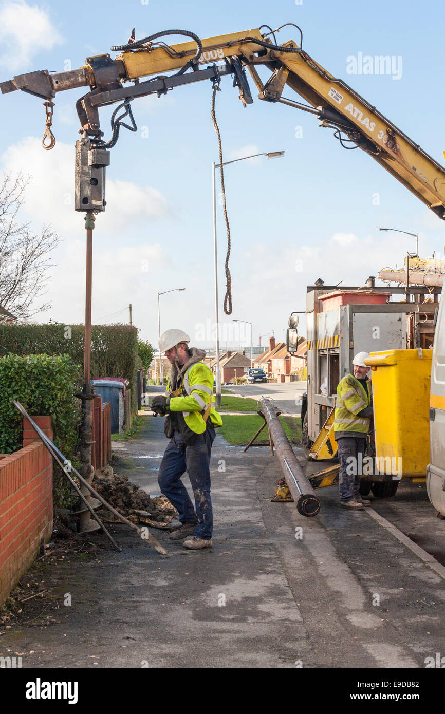 Workmen drilling holes to erect telegraph poles for telephone cables ...
