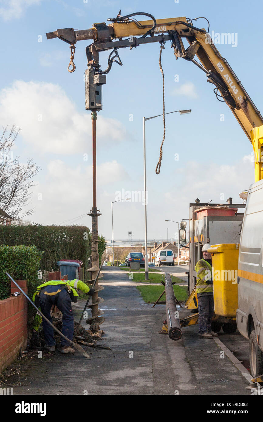 Workmen drilling holes to erect telegraph poles for telephone cables ...