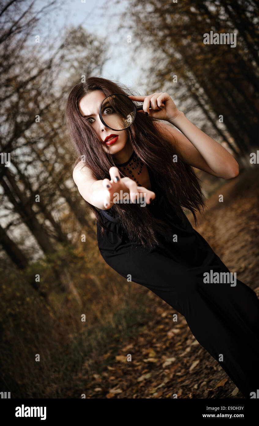 A strange goth girl holds looking glass in hand Stock Photo - Alamy