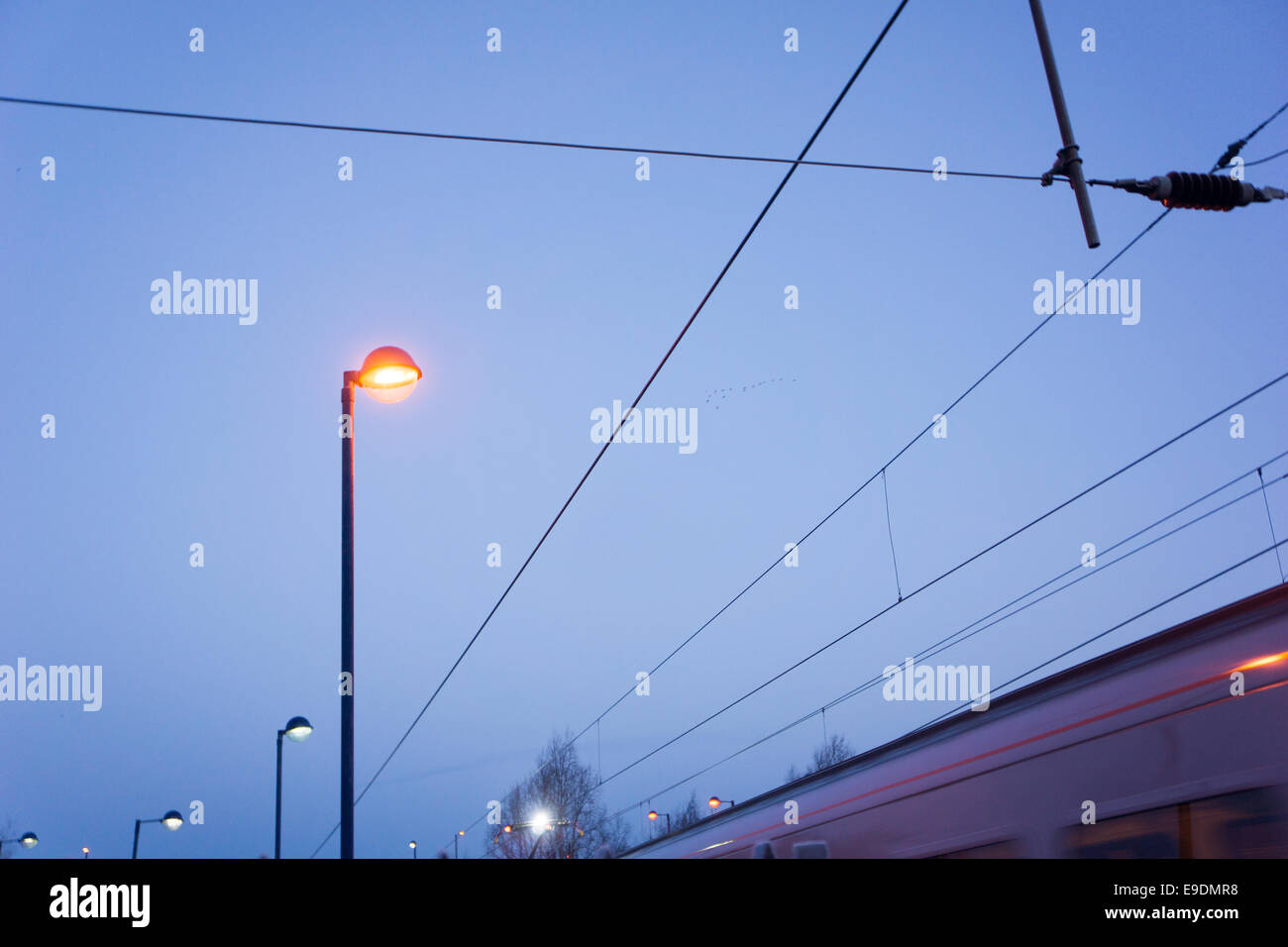 Railway overhead power lines and lights in an evening sky Stock Photo ...