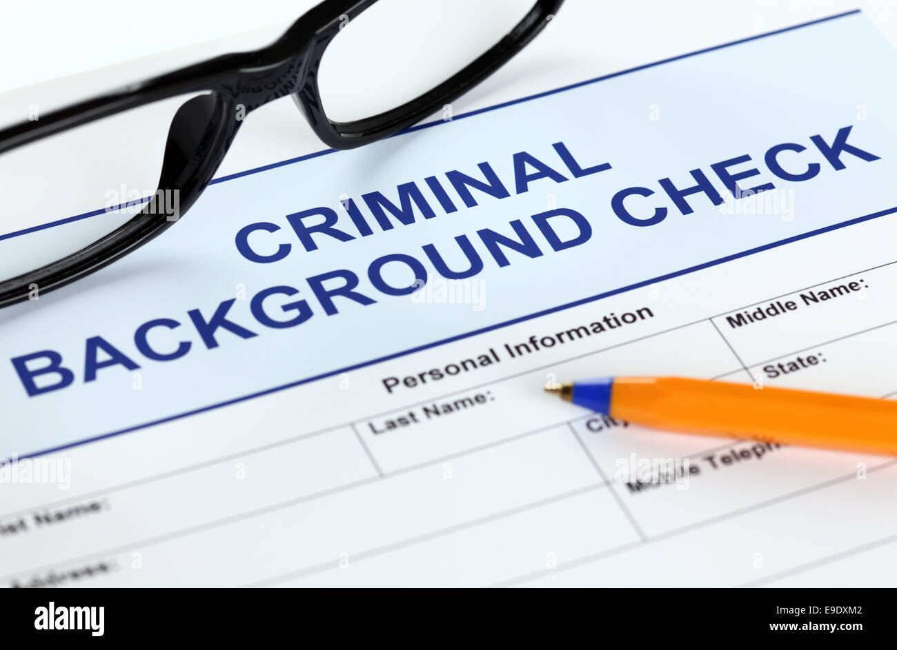 Criminal background check application form with glasses and ballpoint ...