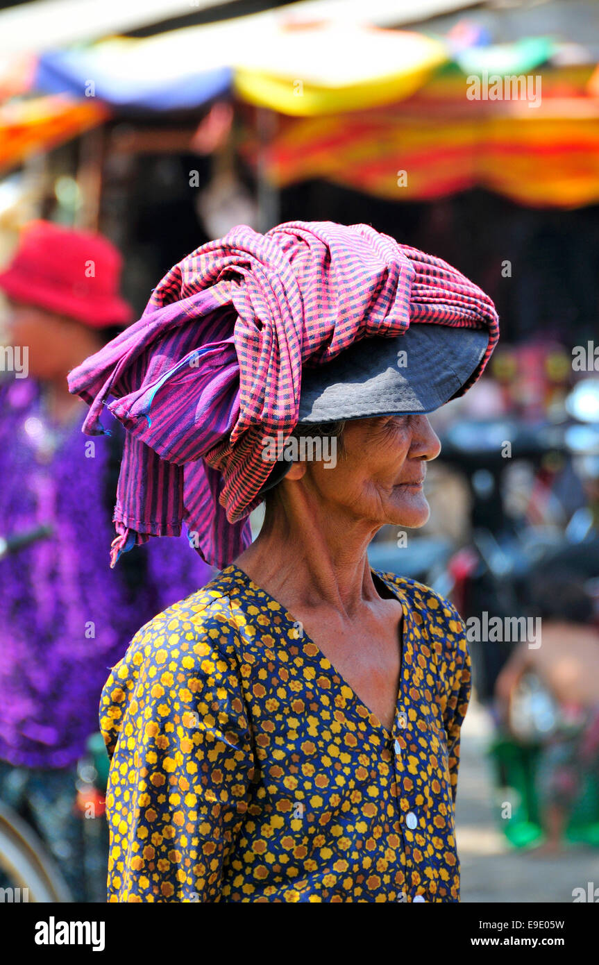 Cambodian woman walking through market with coloured scarf around her ...