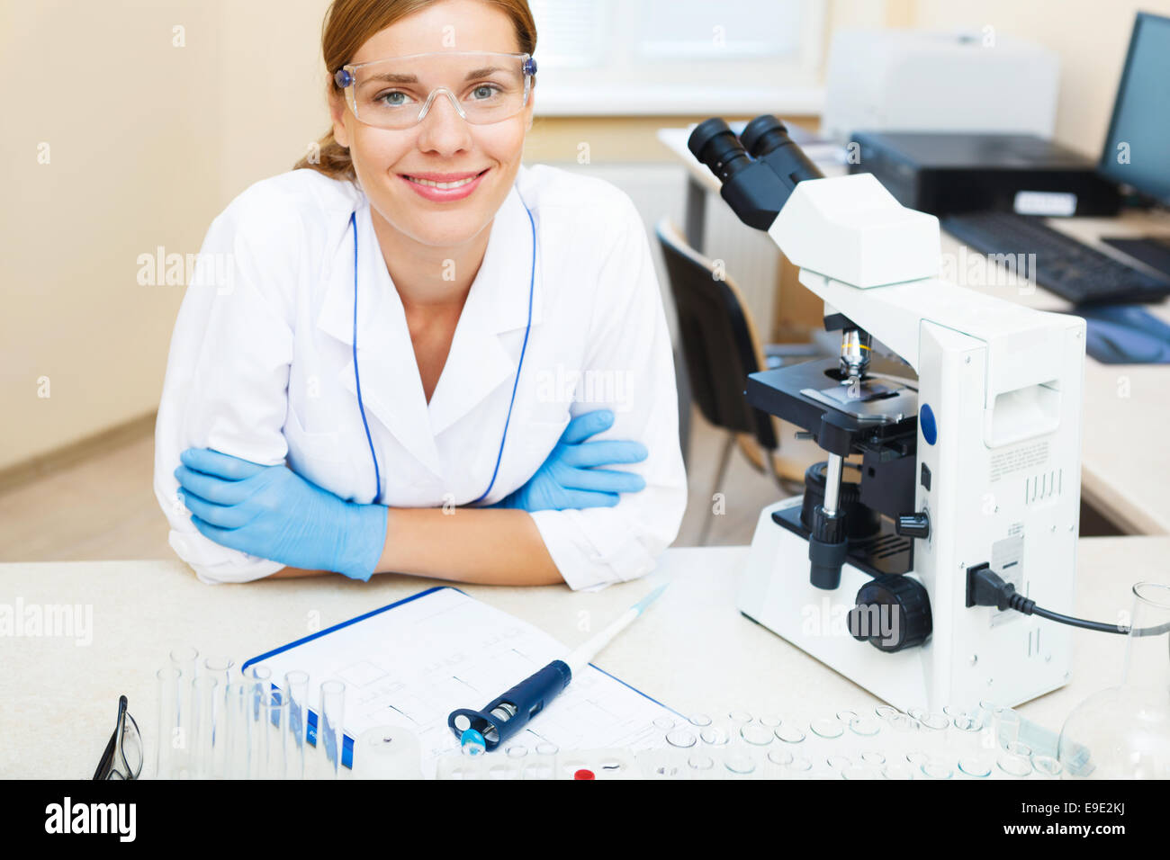Portrait of beautiful young woman in a laboratory sitting on her ...