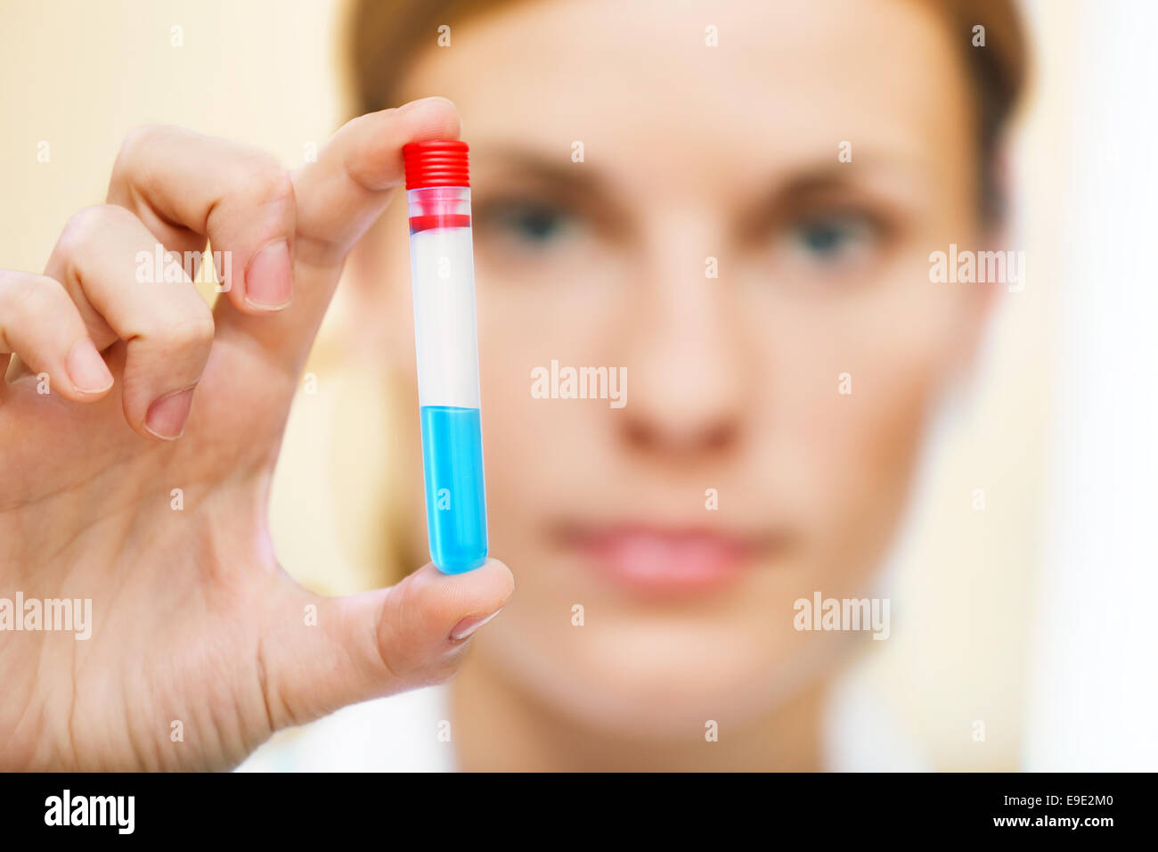 Happy young beautiful scientist holding samples with positive testing ...