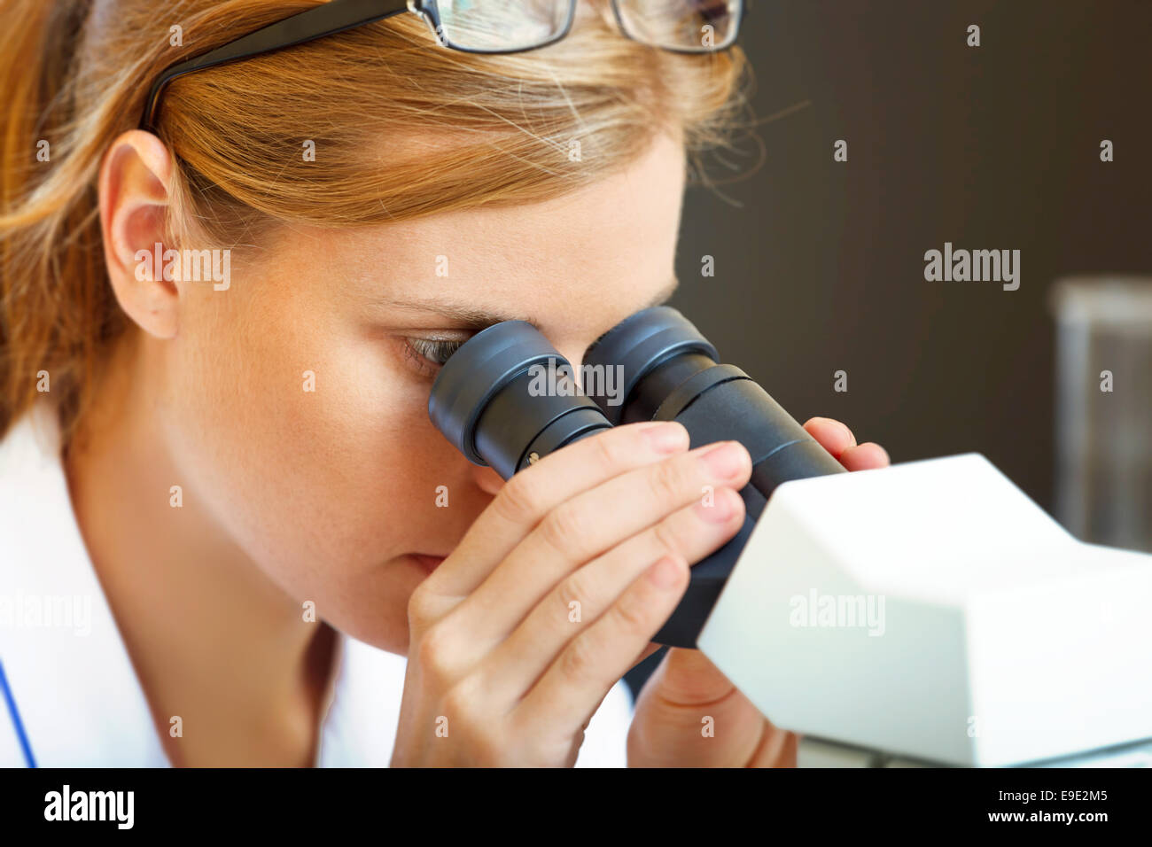 Beautiful woman in a laboratory working with a microscope Stock Photo ...