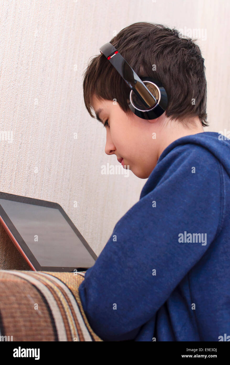 Boy using headphones and his tablet, gadgets, Internet addiction Stock ...