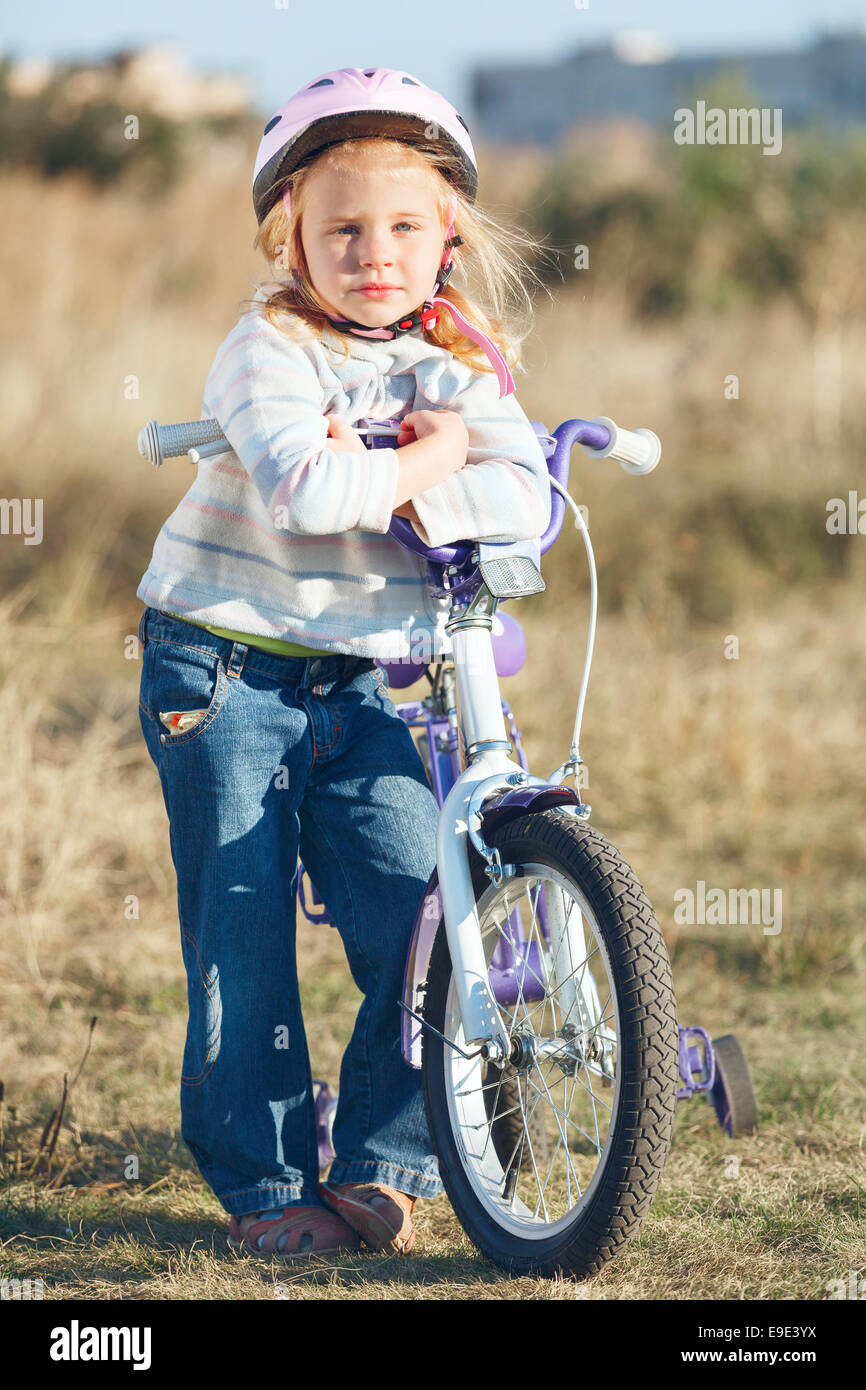 Small funny kid riding bike with training wheels Stock Photo - Alamy