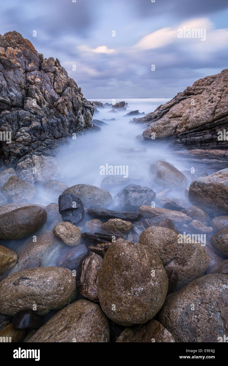 Sunset photograph of misty waves crashing on the rocks by the South ...
