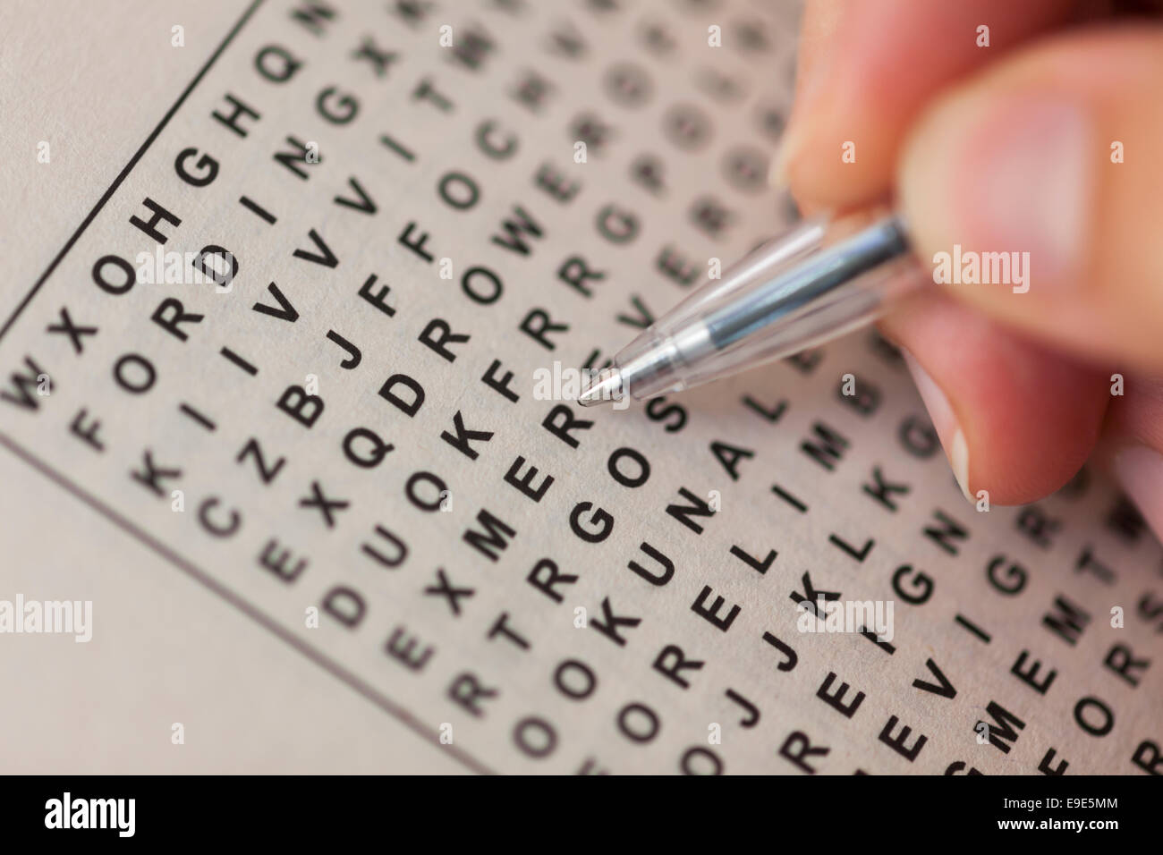 Woman's hand with ballpoint pen and word search puzzle Stock Photo - Alamy