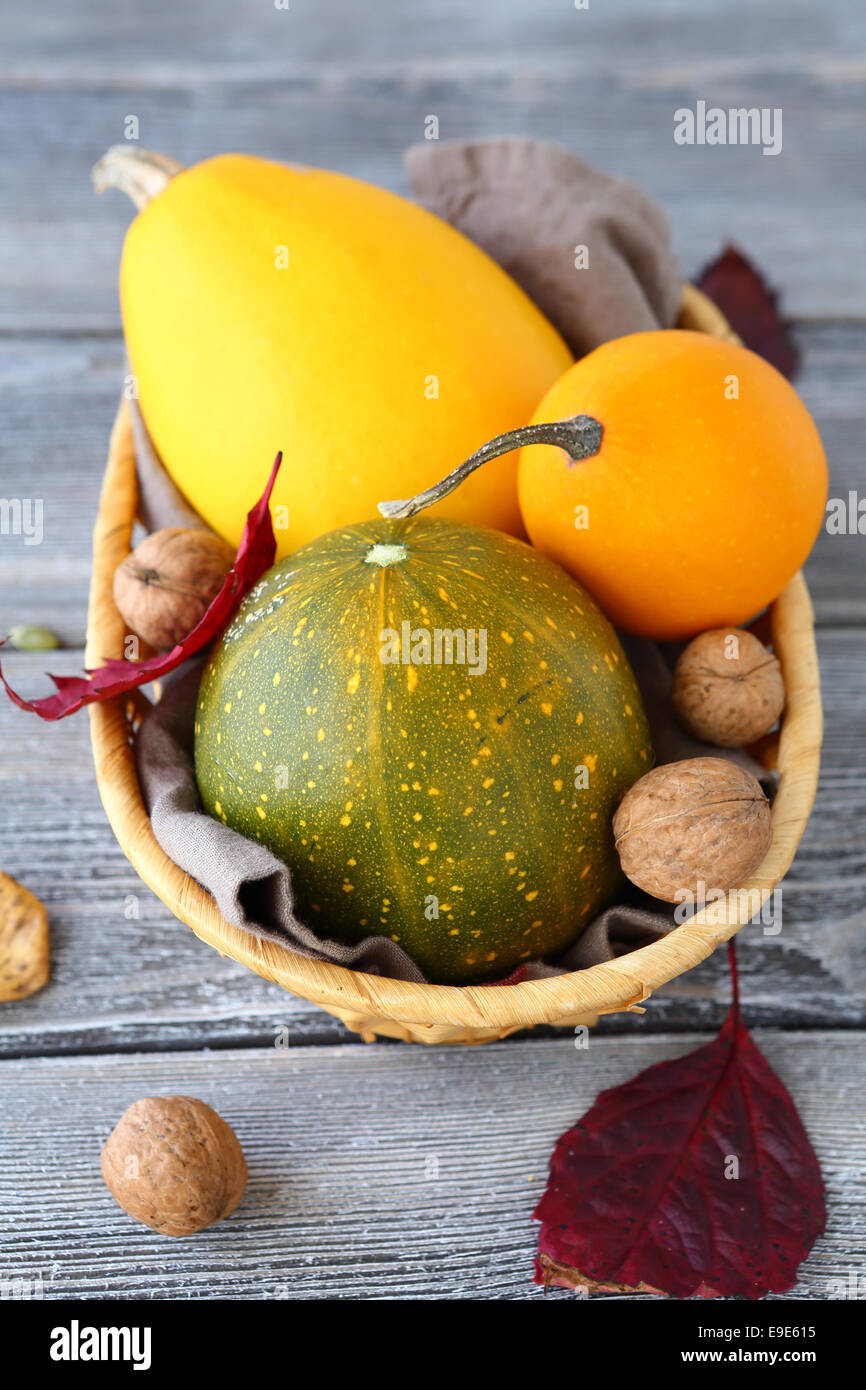 Pumpkins with walnuts in a wicker basket, autumn Stock Photo - Alamy