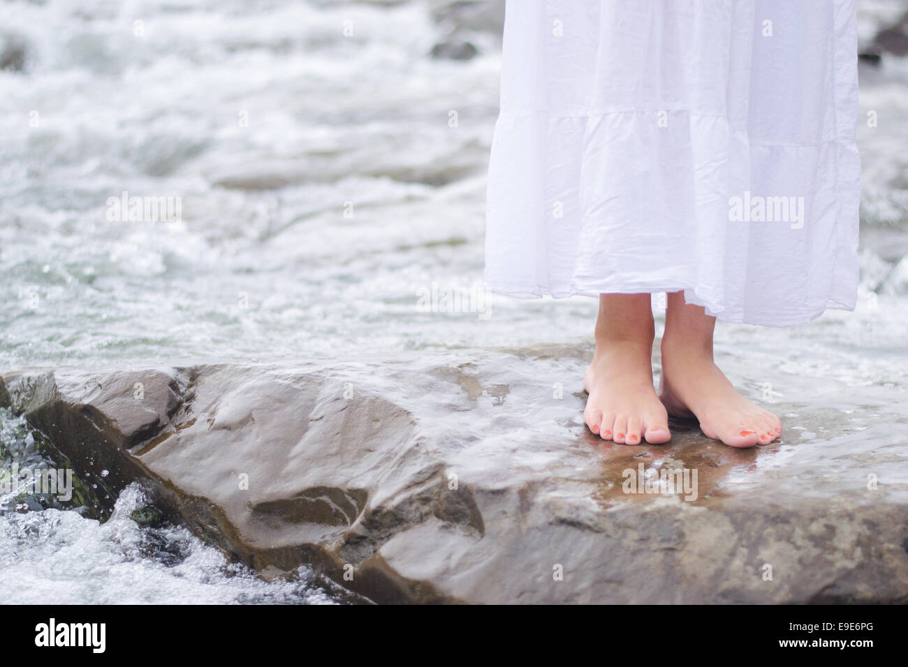 Girl soaking feet in brook Stock Photo - Alamy