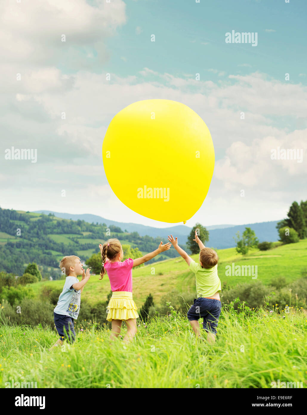 Cheerful kids playing balloon on the fresh meadow Stock Photo - Alamy