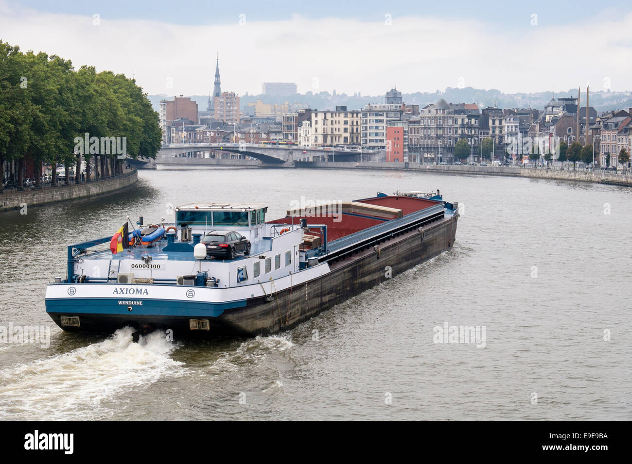 Cargo barge sailing along the River Meuse in Liege, Wallonia, Belgium ...