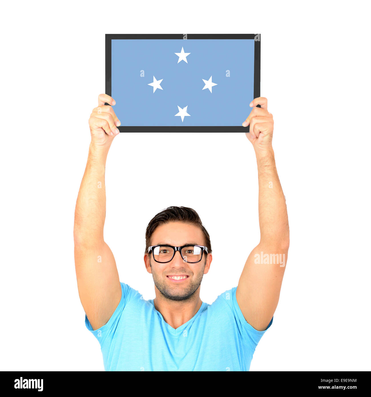 Portrait of a young casual man holding up board with National flag of ...