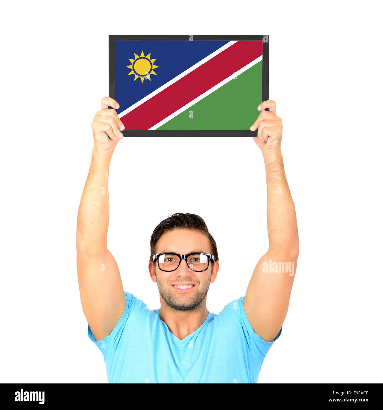 Portrait of a young casual man holding up board with National flag of ...