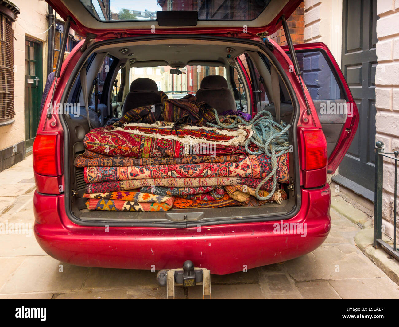 Open rear door of an estate car loaded with folded Persian Arabic ...