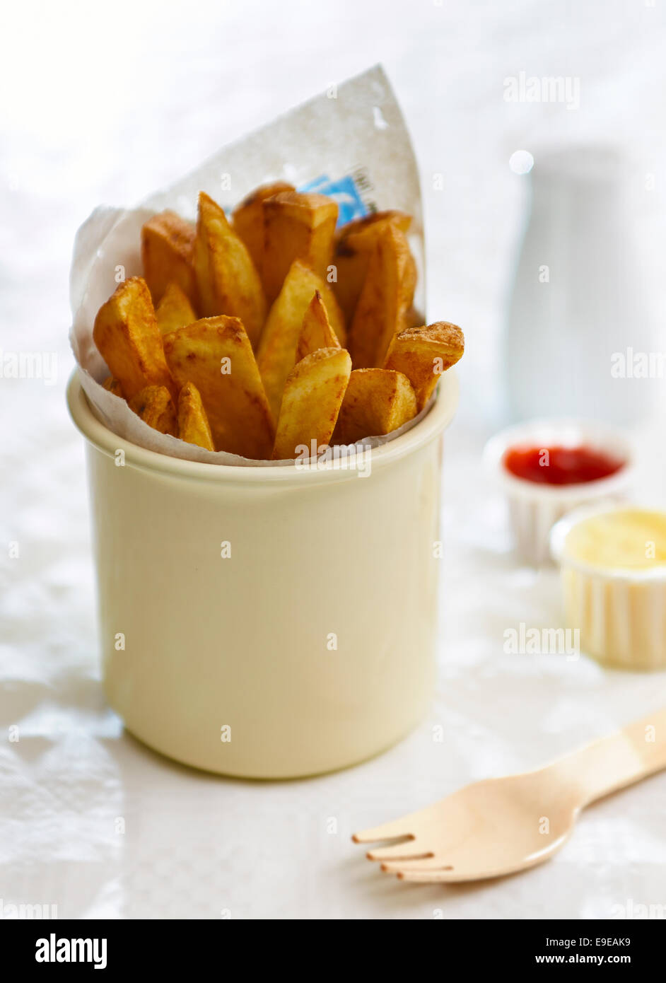 Chips in tin cup with wooden fork Stock Photo - Alamy