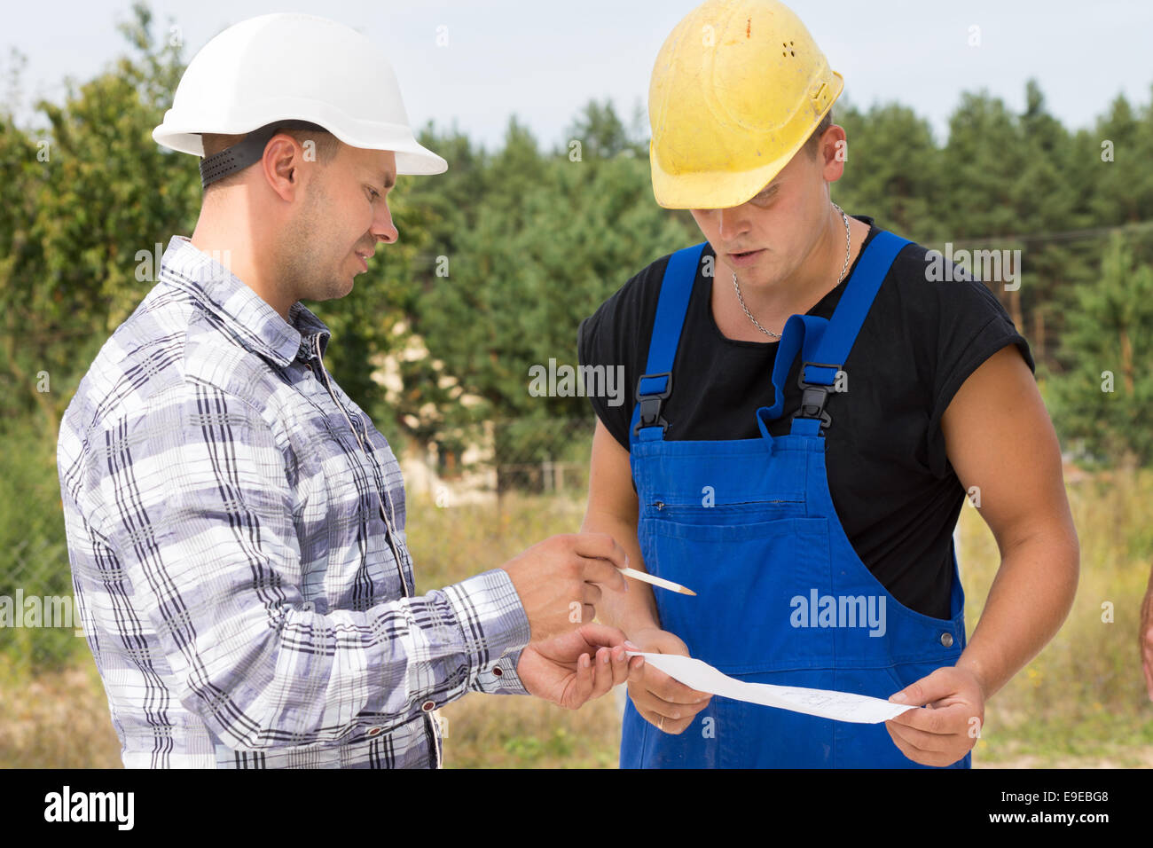 Architect or engineer explaining something to a construction worker or ...