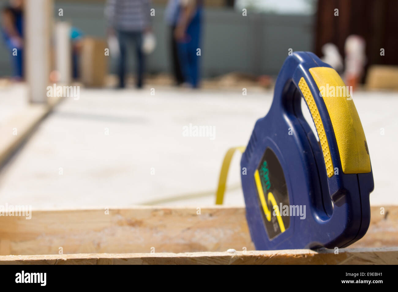 Blue plastic retractable builders tape measure on a building site with ...