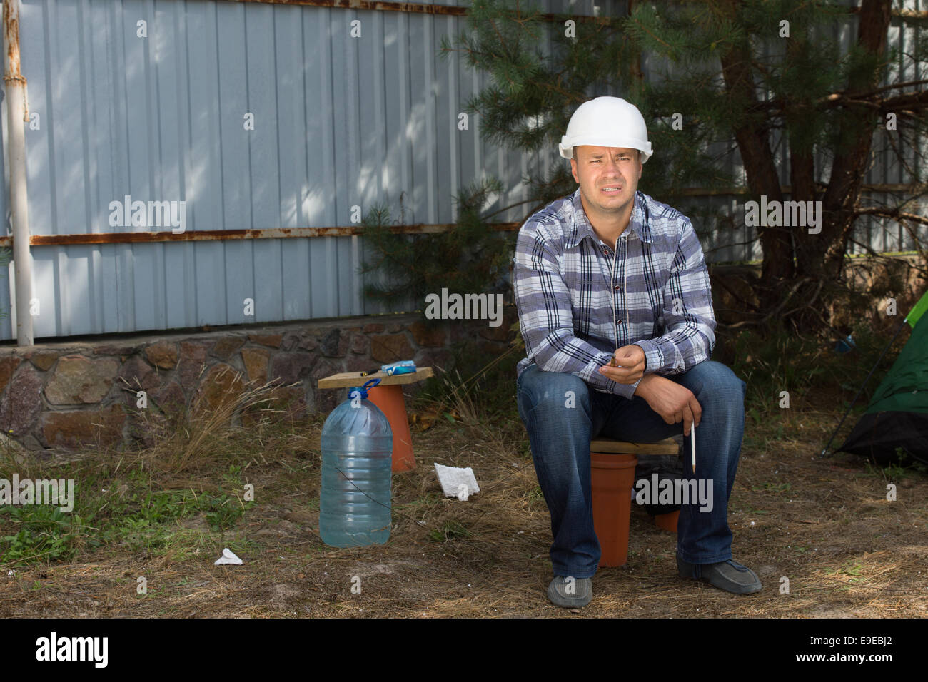 Tired Male Civil Engineer Sitting at the Corner in Construction Site ...