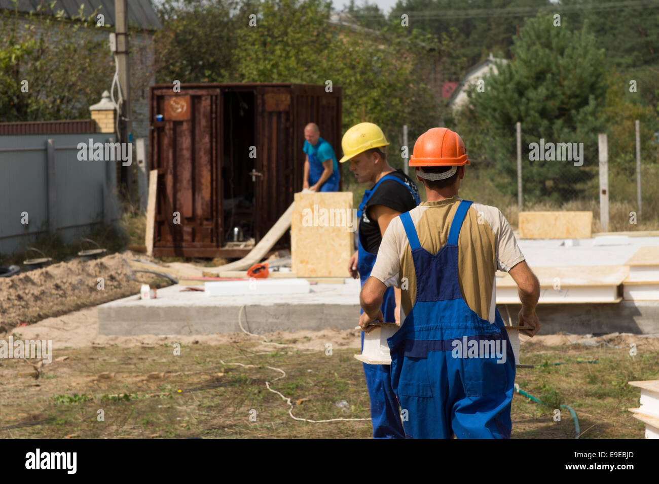 Team of builders or workmen on site at a new build house construction ...
