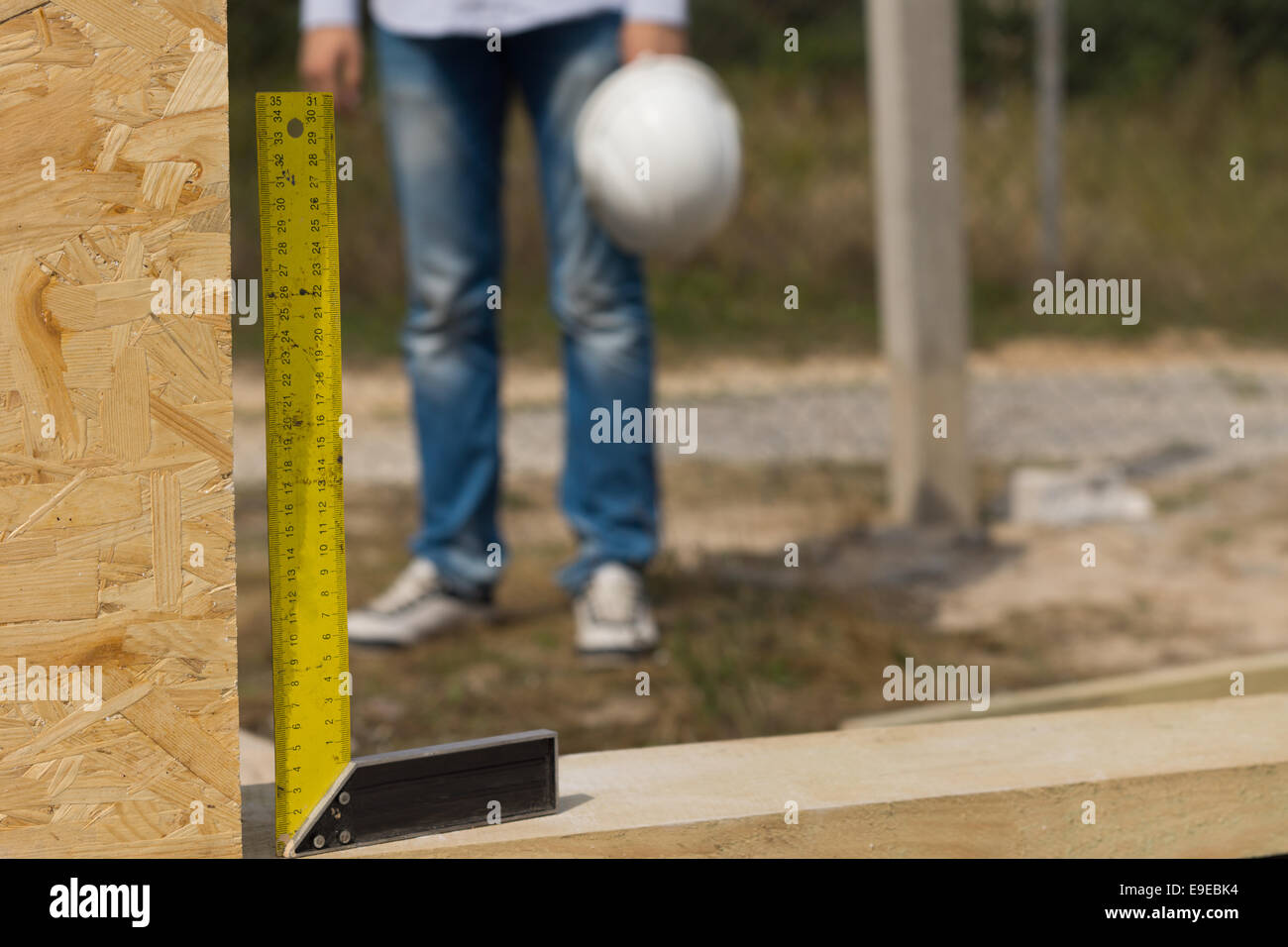 Workman using a builders try square or right angle to make sure that ...