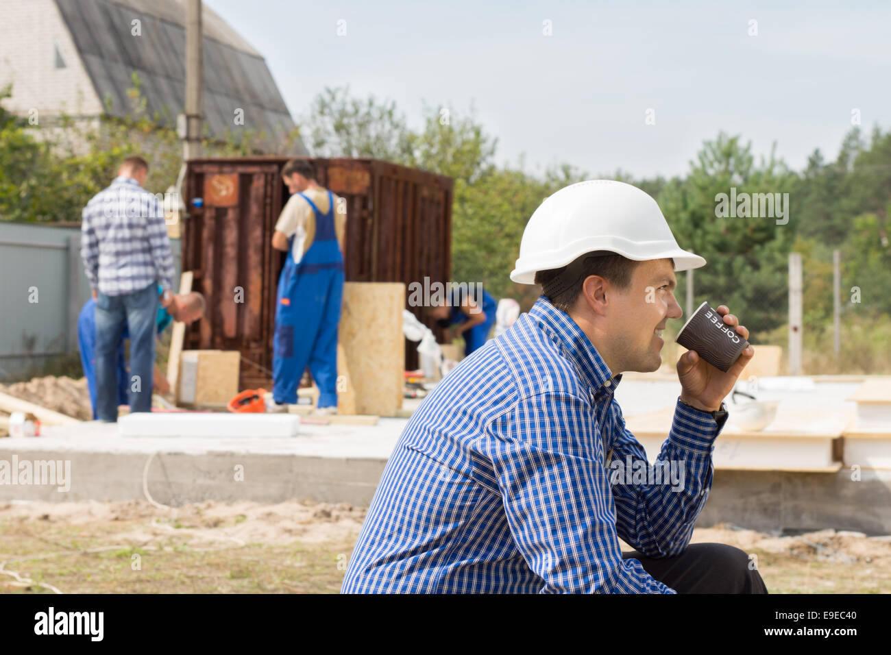 Workman sitting relaxing drinking coffee on a building site while his ...