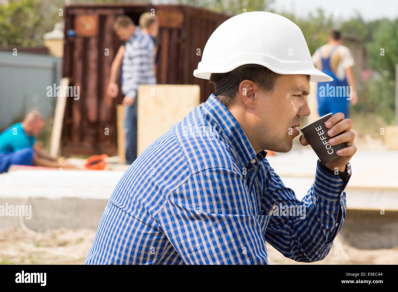 Builder or construction worker sitting enjoying a cup of coffee on site ...