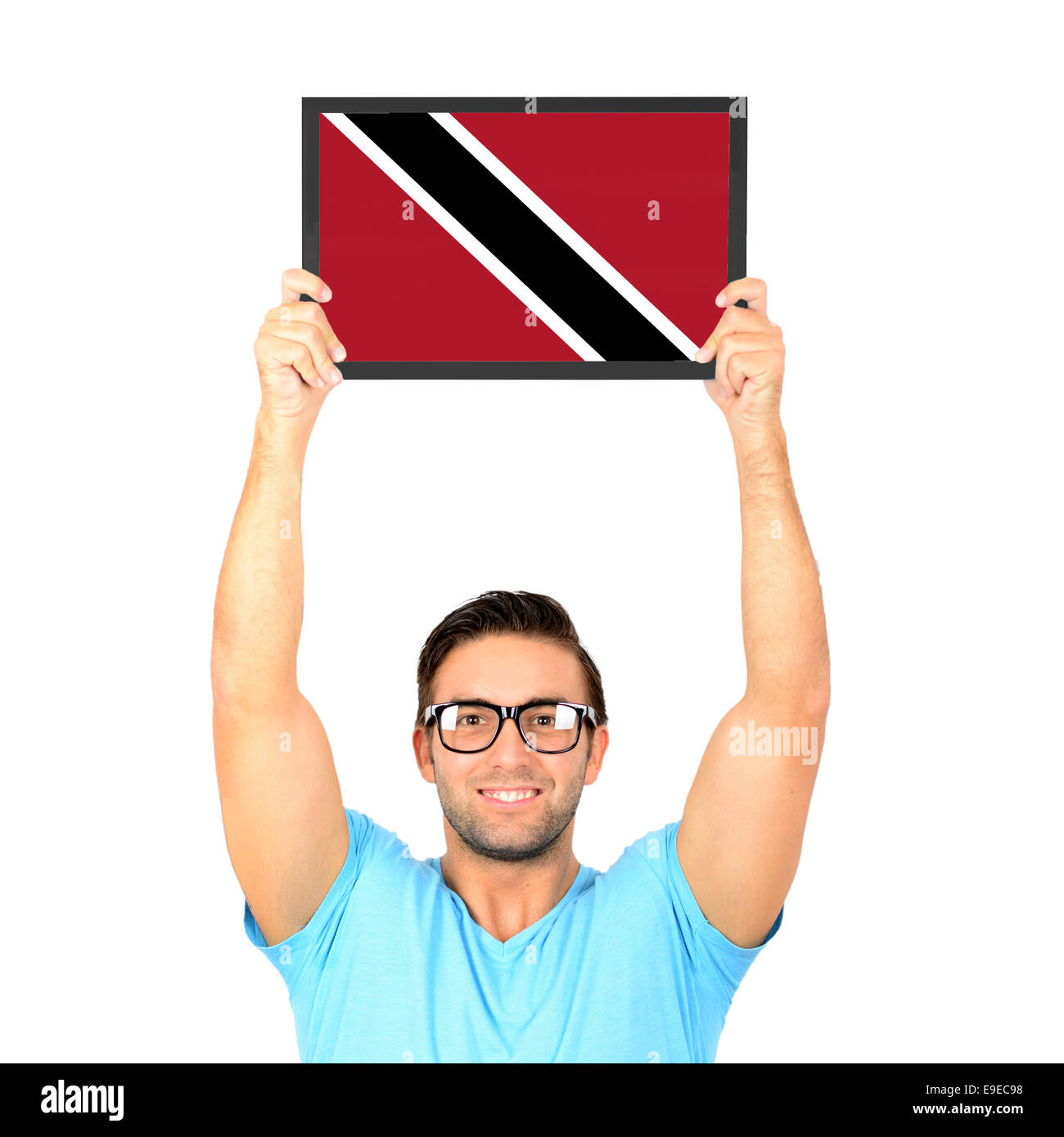 Portrait of a young casual man holding up board with National flag of ...