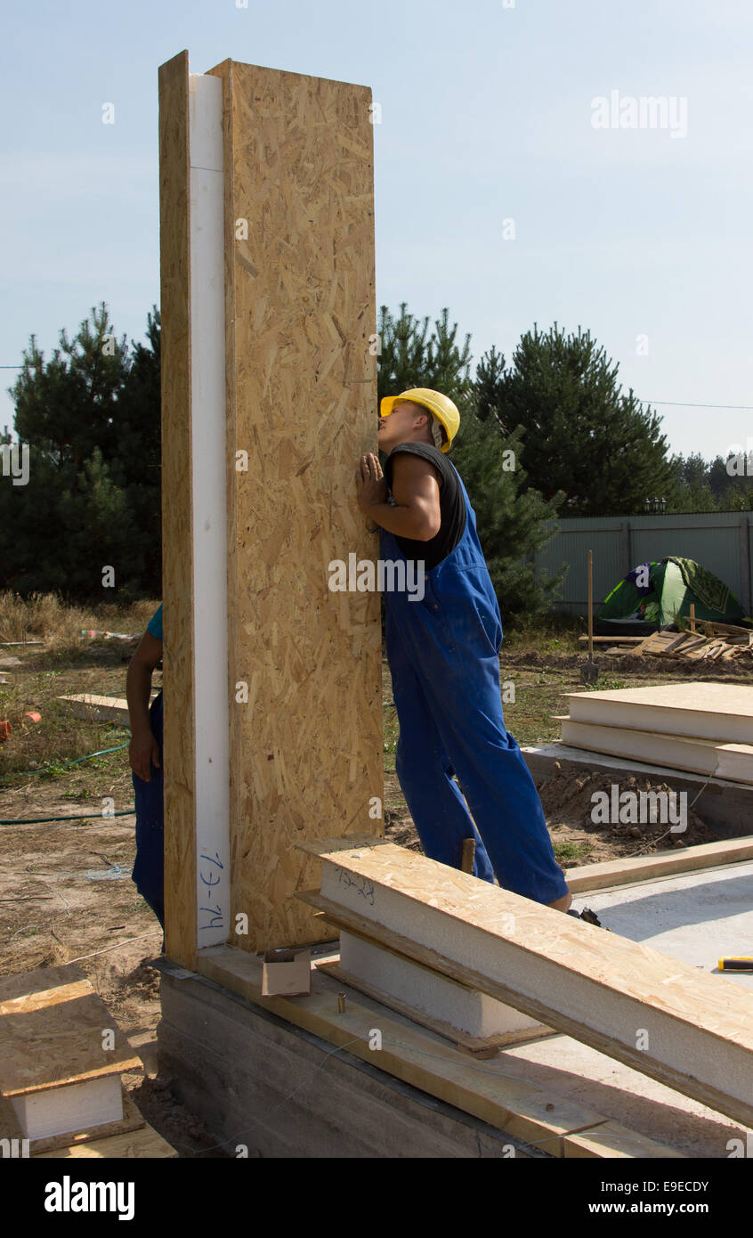 Construction Workers Positioning Timber